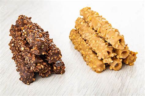 Pyramider Från Waferrullar I Mörk Choklad Och Mjölkchoklad Med Jordnöt På Träbord Arkivfoto
