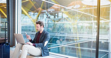 창문 옆에 노트북과 휴대 전화를 사용하여 공항에 앉아있는 남자 사진 Unsplash의 일출 새벽 이미지