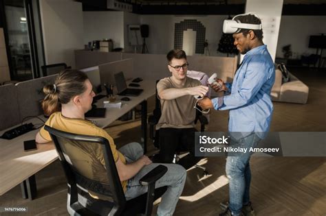 동료가 Vr 헤드셋을 착용하는 데 도움을 줍니다 메타버스 세계를 테스트하고 가상 현실 주제를 만집니다 Vr 프로젝트를 진행하는 It 개발 팀 사무실의 추상 사이버 세계 3