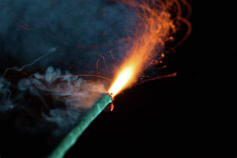Burning fuse with orange sparks and blue smoke Photograph by Lukasz Szczepanski