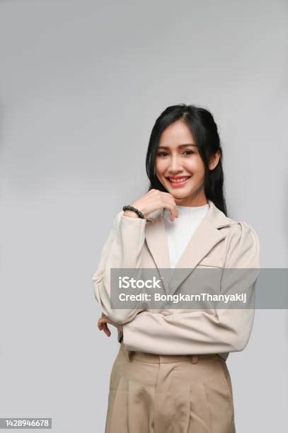 매력적인 아시아 여성이 웃고 턱에 손을 얹고 회색 스튜디오 배경에 고립되어 서 있습니다 미소에 대한 스톡 사진 및 기타 이미지 Istock