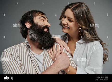 A Couple In Sophisticated Attire Poses Together Laughing And Gazing