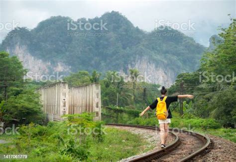Attractive Young Asian Woman Backpacker Walking And Balancing On Train