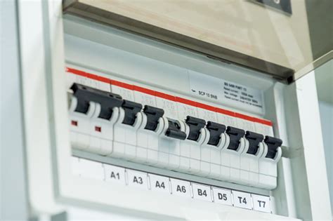 회로 차단기가 있는 전압 스위치보드 손가락이 Rcd 회로 차단기에서 큰 빨간색 Mains 스위치를 끄려고 합니다 회로 차단기 유형 전기 3 상 벽에 설치 되었다