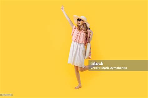 선글라스와 여름 모자를 쓴 매력적인 행복한 젊은 여성이 노란 배경에 대한 승리의 제스처를 보여줍니다 계절에 대한 스톡 사진 및 기타 이미지 Istock