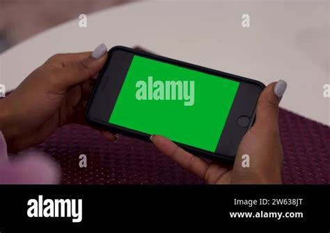 Female black hands uses smartphone with green screen chroma key. Few types of motion - scrolling ...