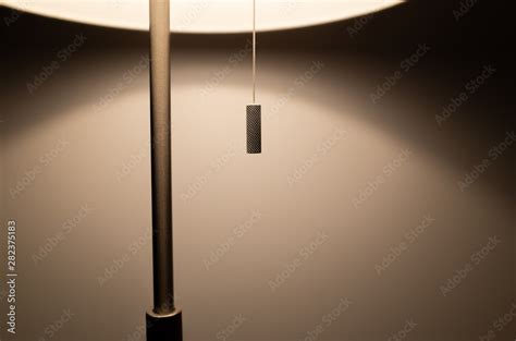 Pull Cord Switch Of A Lamp With Warm Light Against White Wall Concept Of Home Quiet And Night