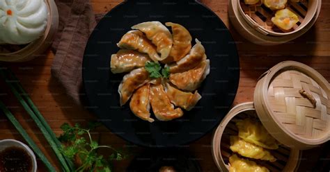 검은 접시에 튀긴 일본 만두 전통 증기선에 제공되는 중국 만두와 롤빵을 곁들인 딤섬의 평면도 사진 Unsplash의 일본 이미지