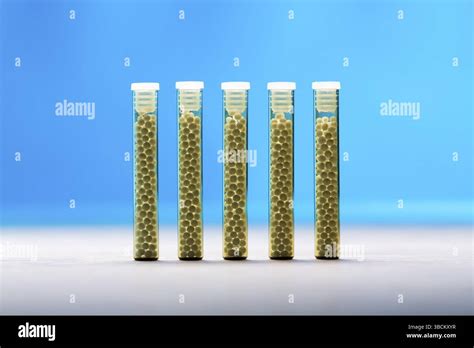 Five Small Glass Tubes With Homeopathy Globules Blue Background Stock