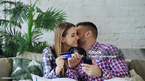 스마트폰 및 인터넷 쇼핑 신용 카드와 함께 매력적인 젊은 부부 집에서 거실에서 소파에 앉아 20 29세에 대한 스톡 사진 및 기타 이미지 20 29세 거실 고객