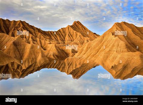 Perfect Reflection Of The Detailed Ridges Of Badlands In Still Water Creating A Symmetrical