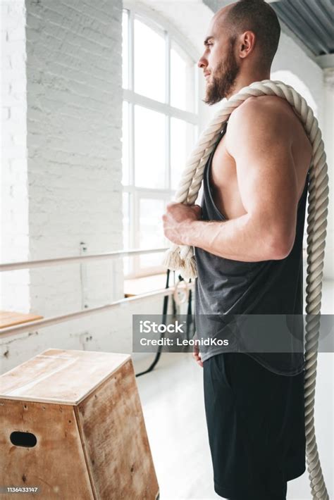 크로스 체육관에서 전투 밧줄을 가진 피트 니스 남자의 초상화 강렬한 운동 후 어깨 밧줄에 들고 강한 남성 선수 수직 건강한 생활