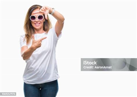 중세 스페인 여자 웃는 행복 한 얼굴로 손가락과 손으로 만드는 프레임 격리 된 배경 위에 패션 선글라스를 착용 창의력과 사진 개념입니다 갈색 머리에 대한 스톡 사진 및 기타