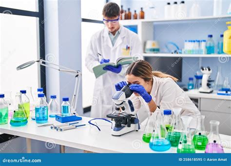 Young Man And Woman Scientists Workers Using Microscope At Laboratory Stock Image Image Of