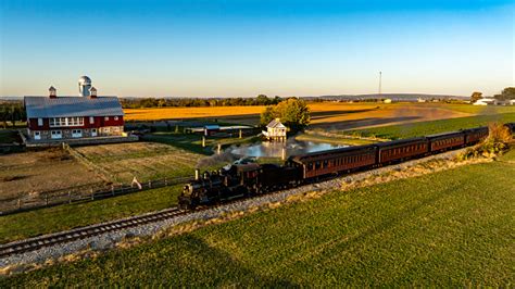 유서 깊은 증기 기관차는 해질녘 붉은 헛간 근처의 농지를 통과합니다 경관에 대한 스톡 사진 및 기타 이미지 경관 고풍스런 기관차 Istock