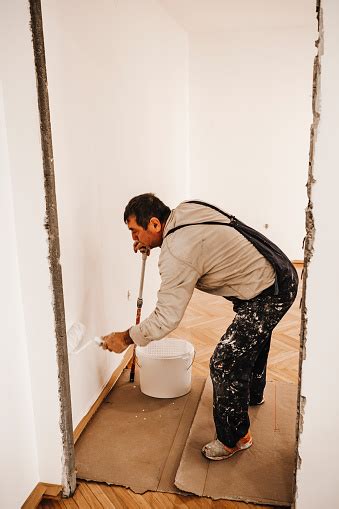 페인트 롤러와 집 화가 홈 인테리어에 흰색 벽을 그리는 것입니다 60 64세에 대한 스톡 사진 및 기타 이미지 60 64세 Diy 가정 생활 Istock