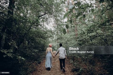 세련 된 Hipster 신부 고 신랑 녹색 여름 숲에서 산책 행복 한 부부 사랑 현대 옷 편안한 공원에 드레스와 모란와 밀 짚 모자 소녀입니다 소박한 결혼식 개념 걷기에