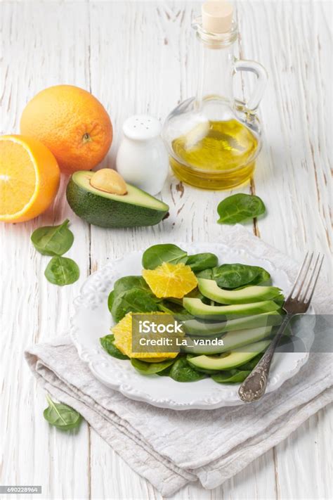 유기농 아보카도 시금치 샐러드와 오래 된 나무 테이블에 흰 접시에 오렌지와 올리브 오일 채식 요리입니다 선택적 초점 아보카도에 대한 스톡 사진 및 기타 이미지 Istock