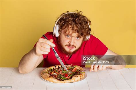 노란 스튜디오 배경에 고립 된 치즈와 토마토와 함께 맛있는 피자를 자르고 먹는 교활한 붉은 수염 남자 25 29세에 대한 스톡 사진 및 기타 이미지 Istock