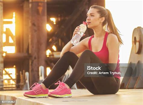 물 균형을 유지입니다 가로 샷 스포츠에 아름 다운 젊은 여자의 다리에 앉아있는 동안 조깅 후 멀리 보고와 식 수를 착용 하십시오 20 29세에 대한 스톡 사진 및 기타