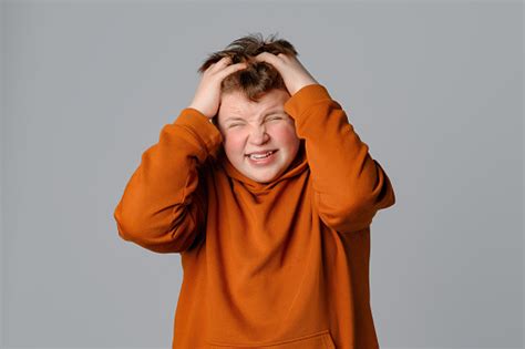 공황 불안 플러스 크기의 십대 소년의 초상화 손을 잡고 회색 배경 위에 서서 좌절 무엇을 해야할지하지 않습니다 16 17 살에