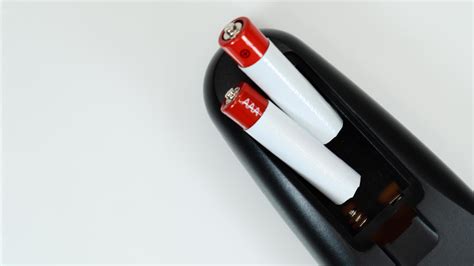 Black Tv Remote Control With Aaa Alkaline Batteries On A White