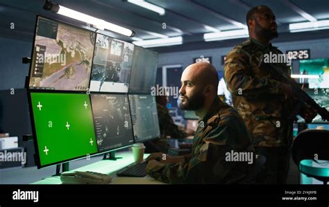 Army Soldier Looking At Chroma Key Screens In Command Center Housing