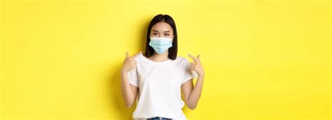 코비드 격리 및 사회적 거리두기 개념 흰색 티셔츠를 입은 젊은 아시아 여성이 약을 가리키고 있습니다 무료 사진