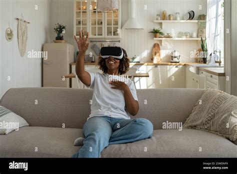 Young Woman In Vr Headset Touches Air Duringvirtual Reality Experience