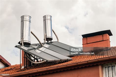 기와 지붕에 주거용 건물의 배관 공사에서 태양 광선으로부터 물을 가열하기 위한 배럴 및 태양 전지판 환경 친화적인 재생 에너지 개념 0명에 대한 스톡 사진 및 기타 이미지