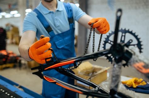 Fábrica De Bicicletas El Trabajador Sostiene El Cuadro De La Bicicleta