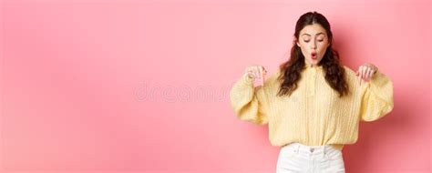 Excited Cute Girl Checking Out Promo Offer On Bottom Pointing Fingers