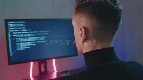 Programmer Coding On A Computer In The Dark With A View Of The Lights