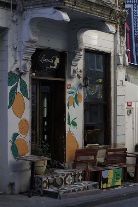 집 밖의 간판 거리 건물 건물 외관 건축 건축의 과일 구조 노란색 도시 도시 풍경 도시의 디자인 램프 레몬 문 문화적 방 벤치 벽감