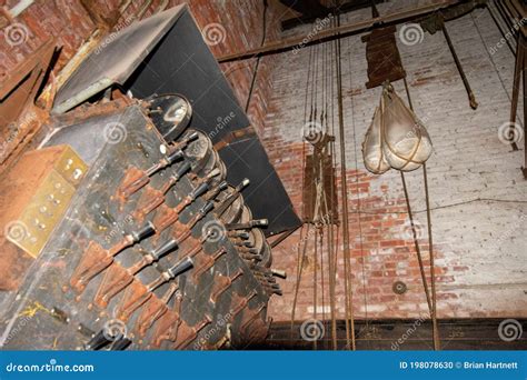 An Old Fashioned Switch Board Full Of Rusty Levers With Black Handles In An Abandoned Theatre