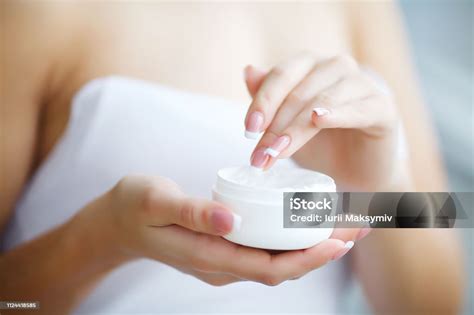 손 피부 관리입니다 여성 손 들고 크림 튜브의 자연 매니큐어 손톱 화장품 핸드 크림을 적용 하는 부드러운 실크 건강 한 피부에 아름 다운 여자 손 닫습니다 보습제에 대한