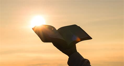 일출 하늘 배경에 아침에 성경과 함께 하나님께 예배하는 기도하는 여성의 실루엣입니다 사람이 손을 펴고 손바닥을 위로 향하게 하여 예배를 드린다 가톨릭 부활절 기도를