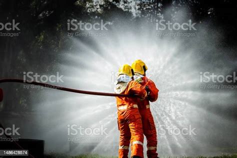 소방관 개념 화재로 싸우기 위해 물과 소화기를 사용하는 소방관 소방 훈련 훈련 중 호스와 물로 화재와 싸우는 소방관 2명에 대한 스톡 사진 및 기타 이미지 Istock
