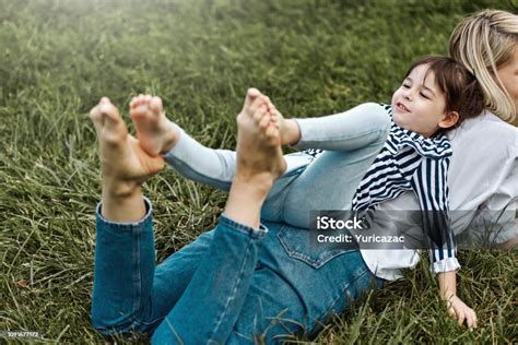 거짓말을 하 고 야외 녹색 잔디에 그녀의 귀여운 어린 소녀와 놀고 아름 다운 여자의 수평 이미지 행복 한 아이 어머니는 공원에서 시간 함께 지출 어머니의 날 개념 가족에