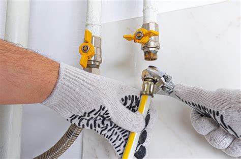 가정용 보일러실의 가스 누출로 인한 강화 프로판 가스 호스를 교체하기 위해 유지 보수 엔지니어가 손에 들고 있는 조정 가능한 렌치 보일러에 대한 스톡 사진 및 기타 이미지