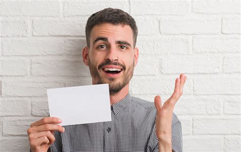 벽돌 벽 매우 행복 하 고 흥분 빈 종이 들고 상자 식 축 하 승리 큰 웃음과 비명과 손을 통해 젊은 성인 남자 간판에 대한 스톡 사진 및 기타 이미지 Istock