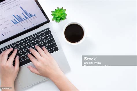 비즈니스 핸드의 상단 보기는 현대적인 흰색 책상에 노트북 컴퓨터 화면의 그래프를 분석하는 것입니다 평평한 복사 영역이 있습니다