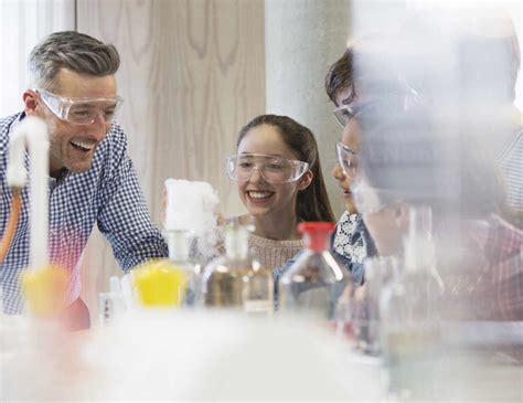Male Science Teacher And Babes Laughing Conducting Scientific Experiment In Laboratory
