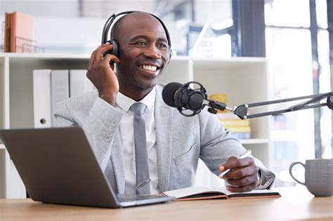 뉴스 노트북 라디오는 생방송 중에 노트북에 글을 쓰는 흑인 남성 발표자와 함께합니다 토크쇼나 언론을 위해 미디어에서 일하는 남성 기자와 함께 있는 컴퓨터 팟캐스트 및 마이크