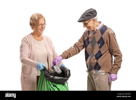 Elderly Man And Woman Putting A Waste Can In A In A Plastic Garbage Bag Isolated On White