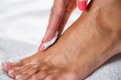 Self Care As A Woman Nourishes Her Feet With A Softening Repair Cream