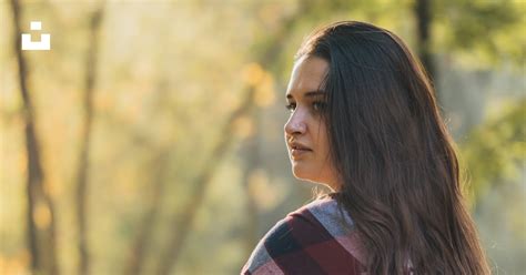 빨간색 흰색과 파란색 격자 무늬 셔츠와 파란색 데님 청바지를 입은 여자가 땅에 앉아 있다 사진 Unsplash의 무료 의복 이미지