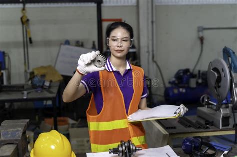 Asian Woman Industrial Engineer In Vest Hold A Clipboard And Looking Check A Example Small Gear