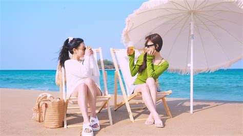 우정 여행 해변 바닷가 앞에서 의자에 앉아 사진을 찍어주려하는 젊은 여성 친구들 모습 동영상 Jkr251359 게티이미지뱅크