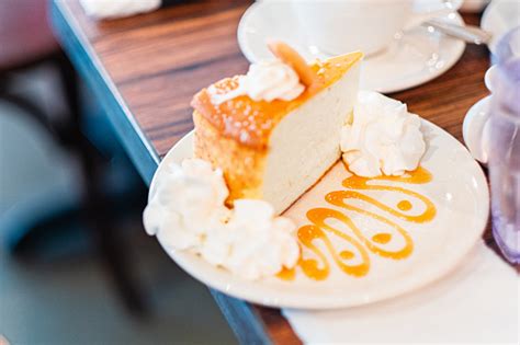 휘핑크림과 캐러멜 소스를 곁들인 식욕을 돋우는 치즈케이크 한 조각이 아늑한 카페 분위기에서 펼쳐집니다 Comfort Food에 대한 스톡 사진 및 기타 이미지 Istock